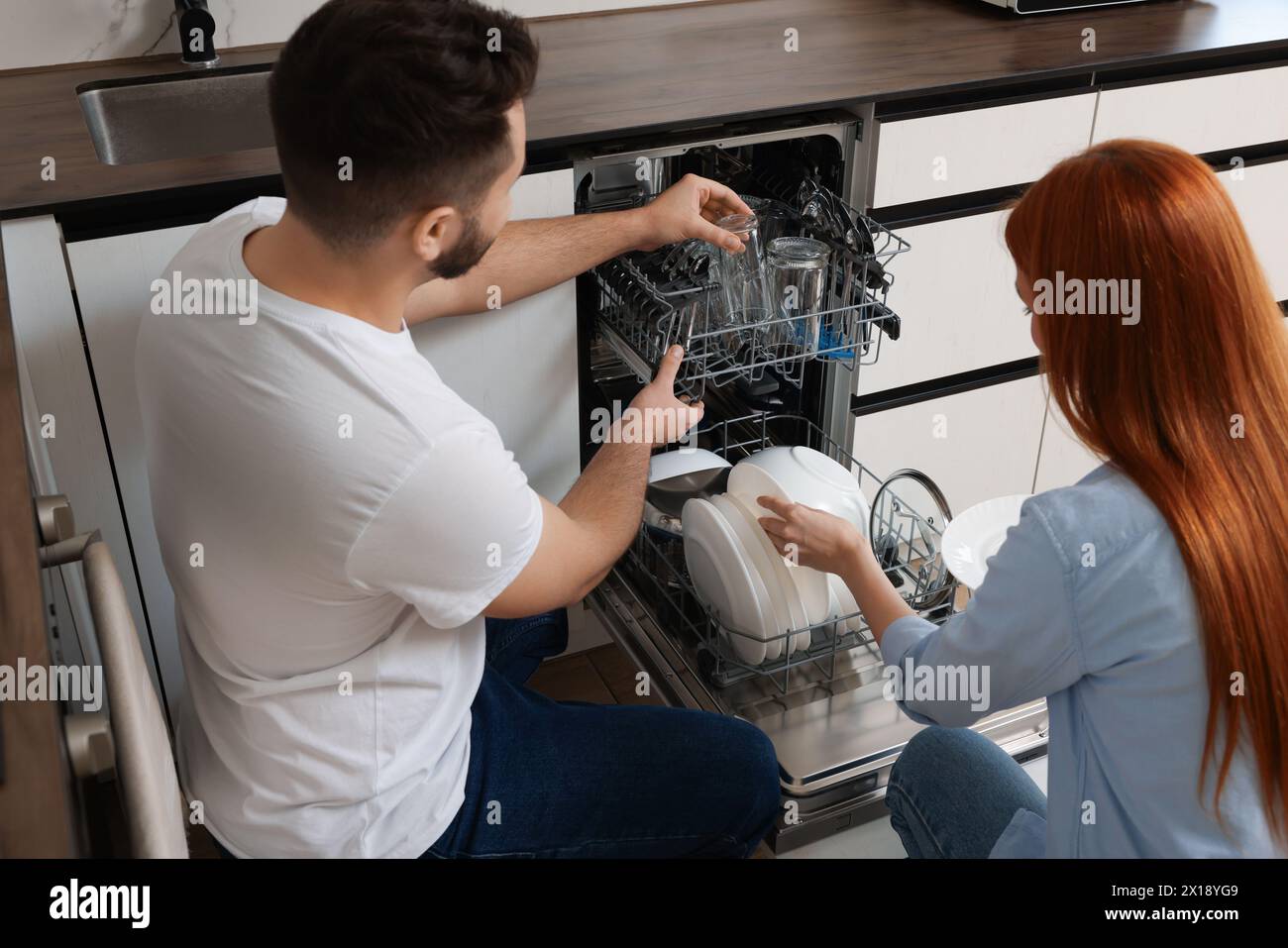 Man loading dishwasher woman hi-res stock photography and images - Alamy