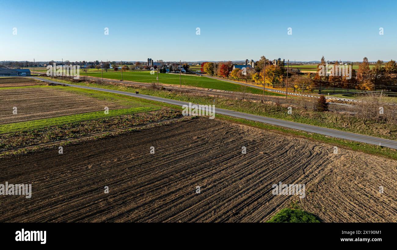An aerial image captures the textured farmland during autumn, with a ...
