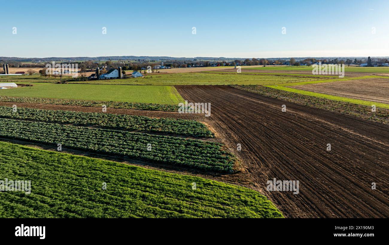 The image displays a bird's-eye view of diverse farm plots in the fall ...