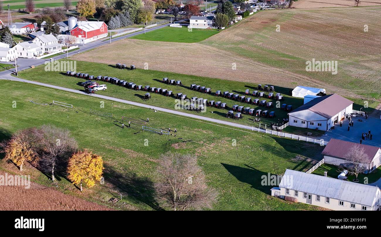An aerial snapshot of a rural community event, with rows of horse-drawn ...
