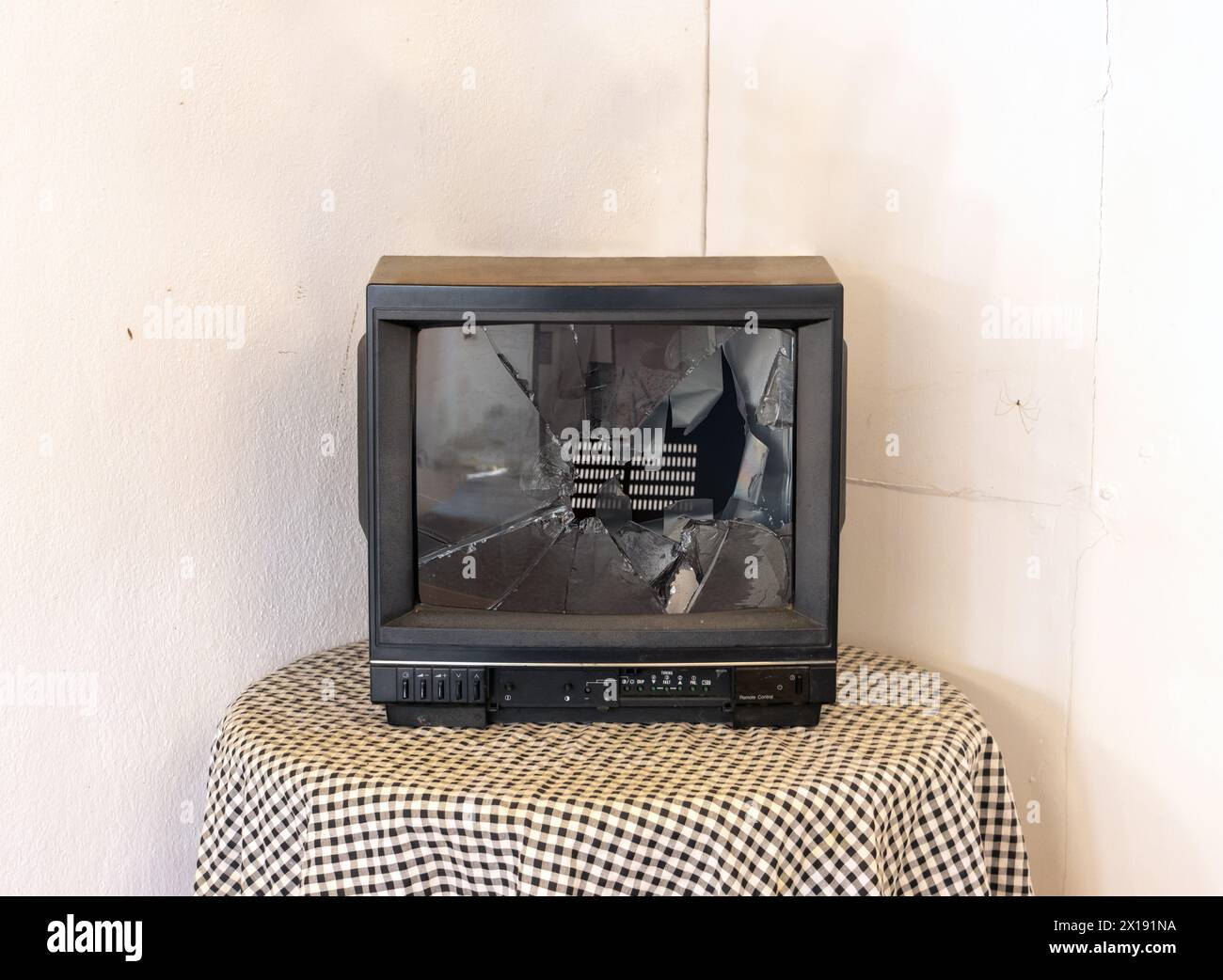 A broken television on a round table in the corner of the room Stock ...