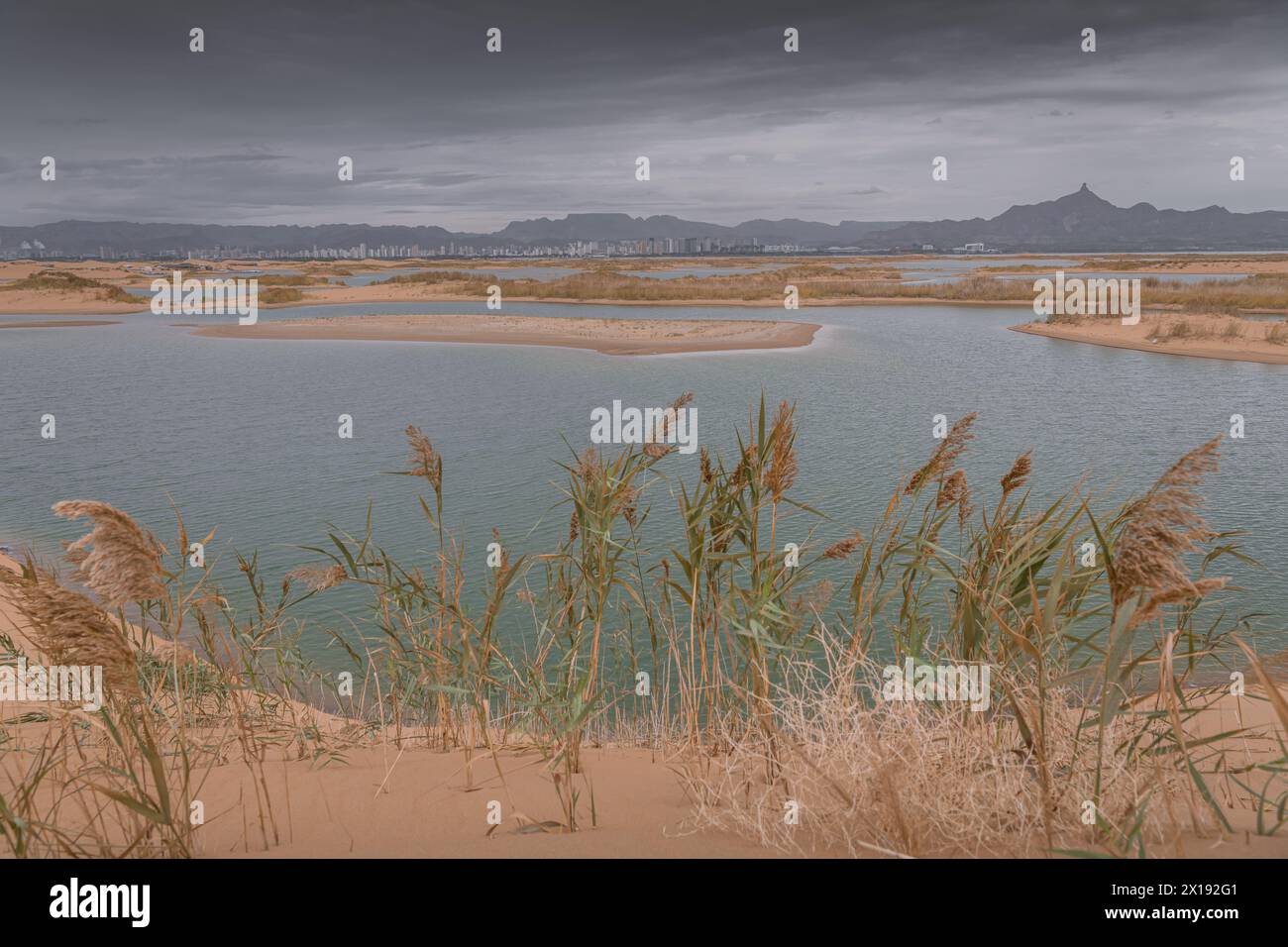 Desert vastness next to lake in Wuhai, Inner Mongolia, China. Dramatic ...