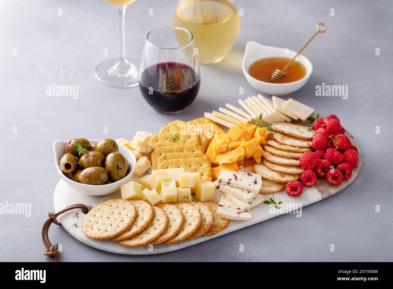 Cheese and snacks board with cheddar, swiss cheese, olives and crackers ...