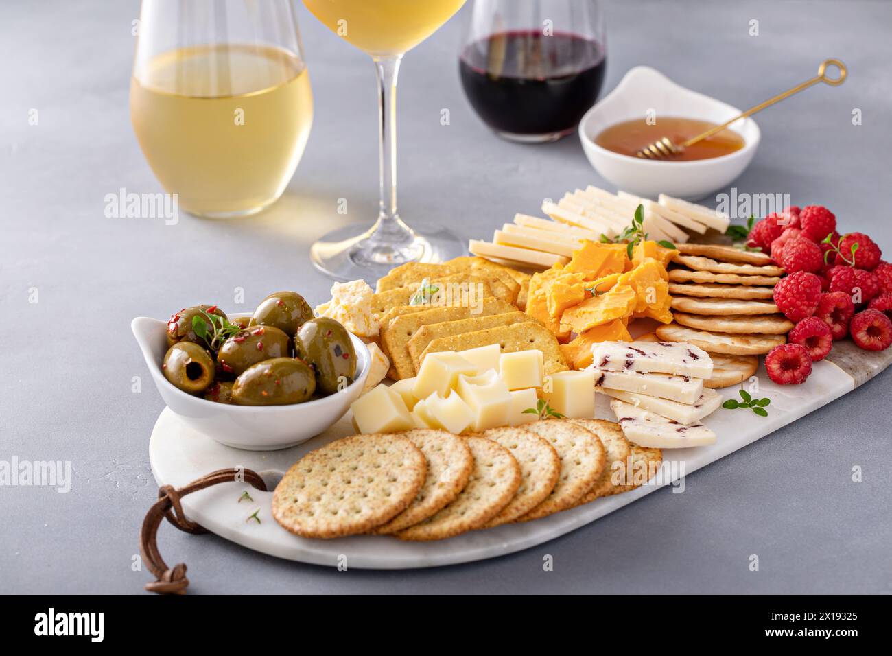 Cheese and snacks board with cheddar, swiss cheese, olives and crackers ...