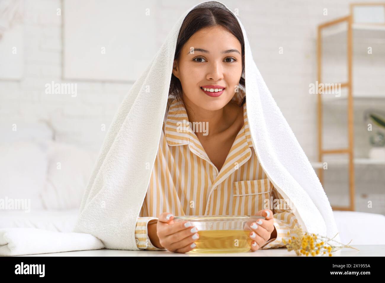 Young Asian woman doing steam inhalation at table in bedroom Stock ...