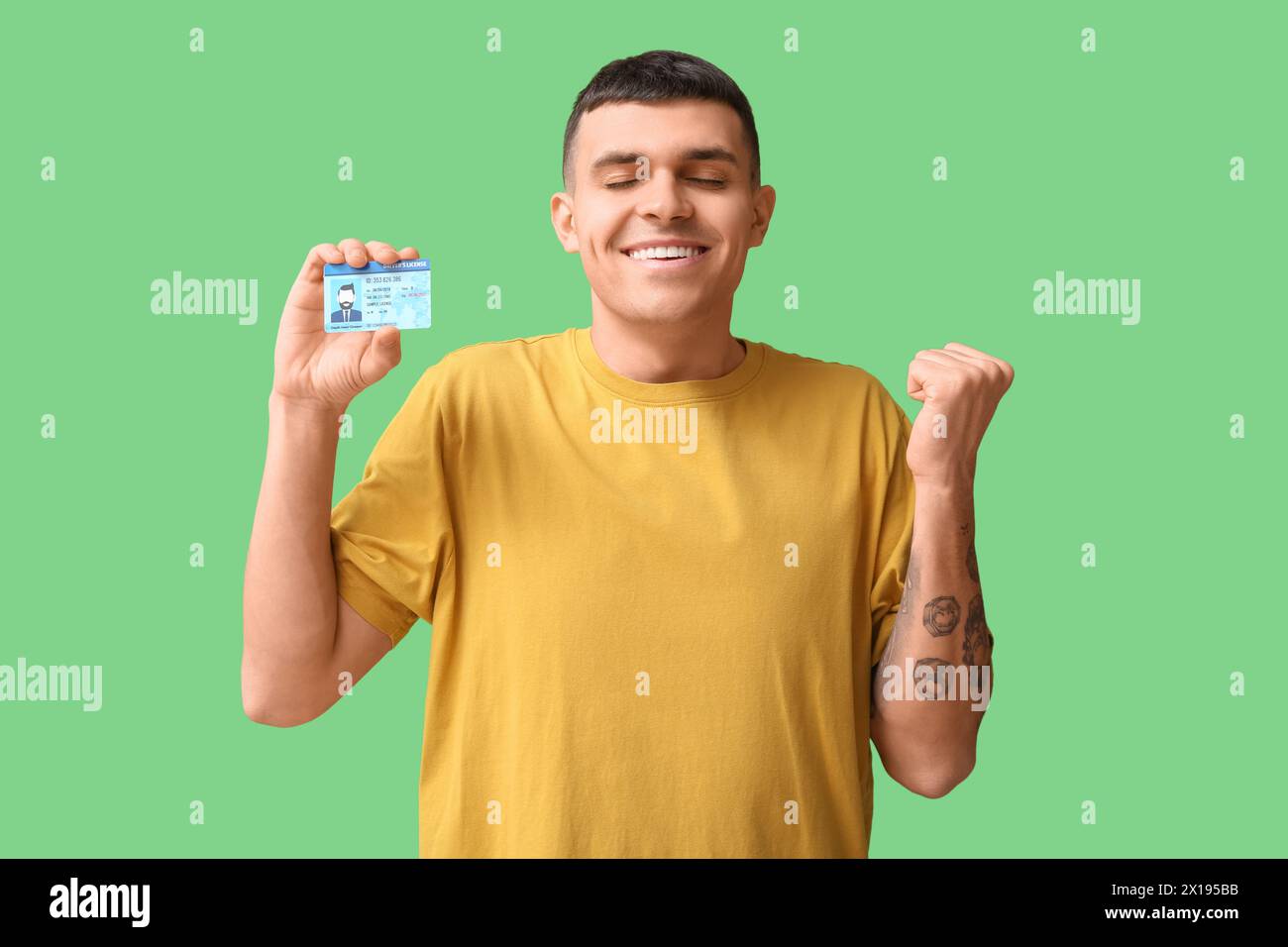Young happy man holding driver license on green background Stock Photo ...
