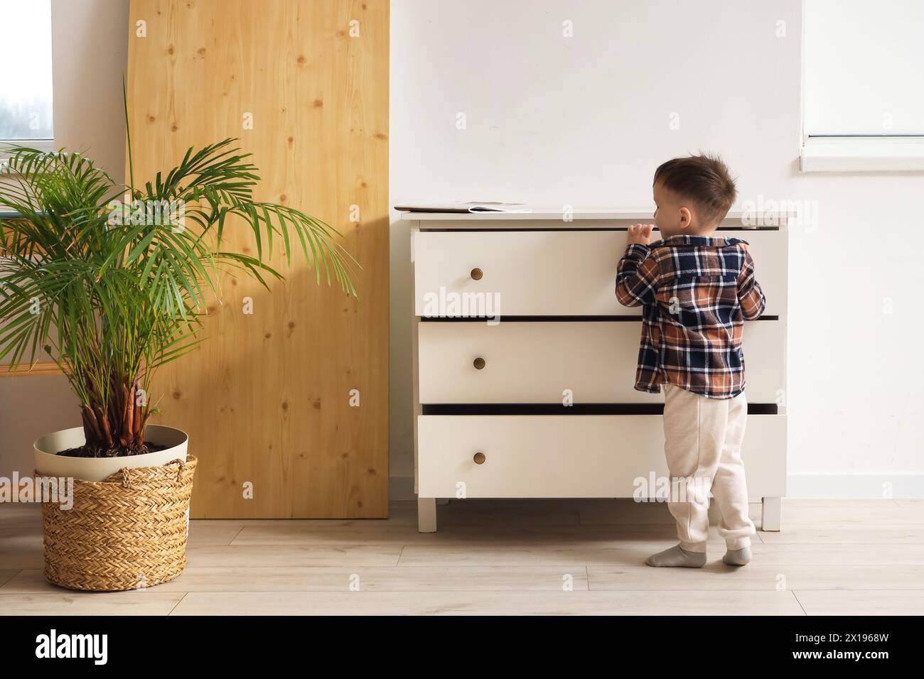 Little boy opening drawers at home, back view. Child in danger Stock ...