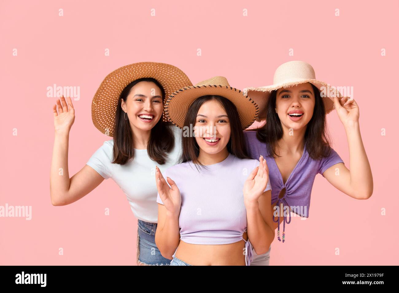 Beautiful young women in wicker hats on pink background. Summer party ...