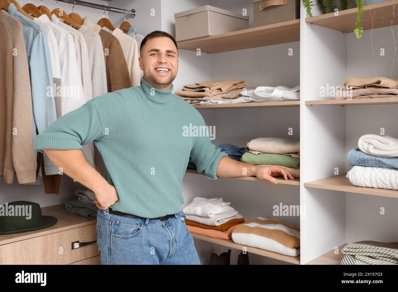 Portrait of young man with clothes in walk-in closet Stock Photo - Alamy
