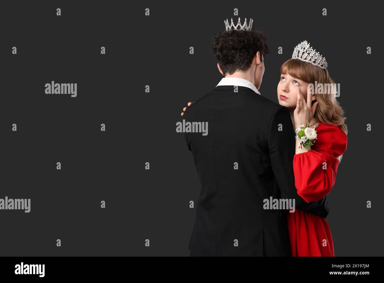 Young girl hugging her prom date and crying on black background Stock ...