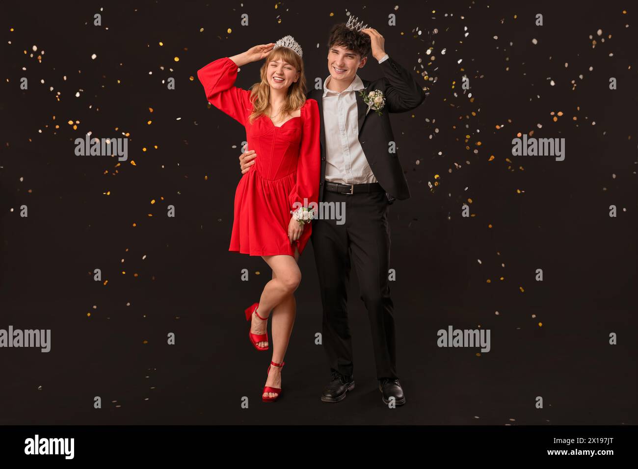 Happy prom couple with crowns and confetti on black background Stock ...