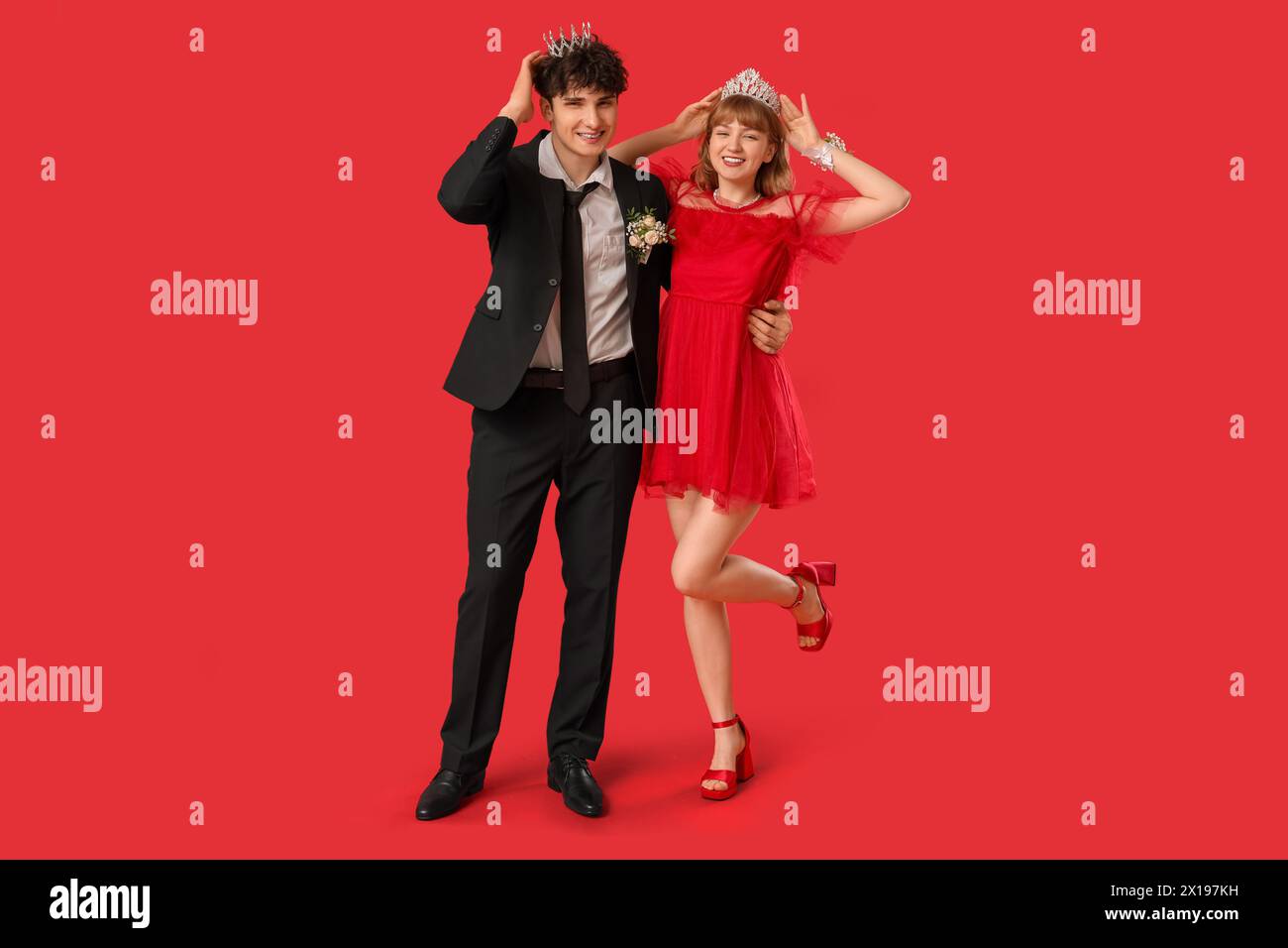 Happy prom couple in crowns on red background Stock Photo - Alamy