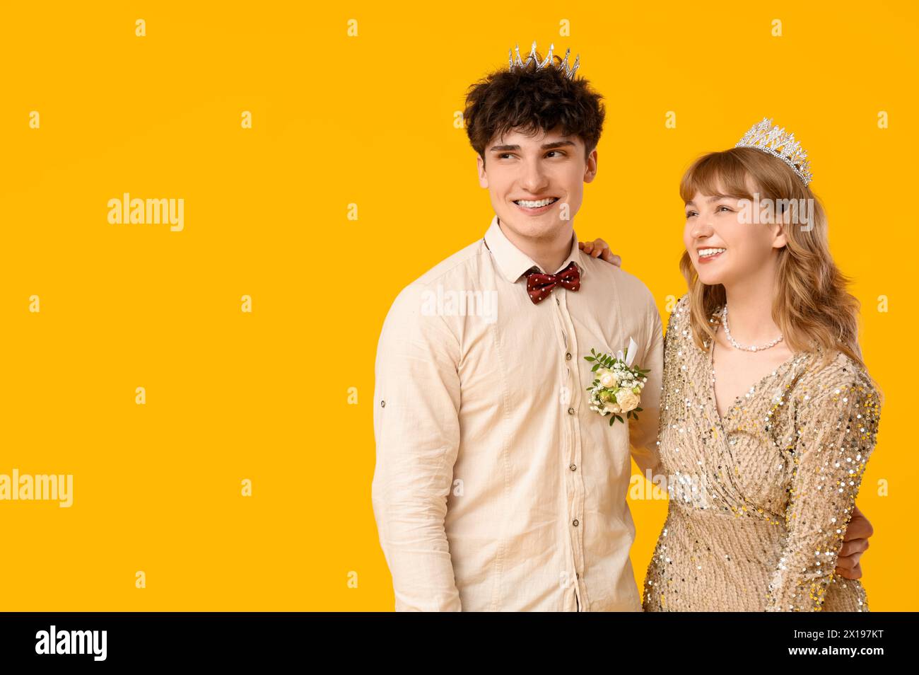 Happy prom couple in crowns on yellow background Stock Photo - Alamy
