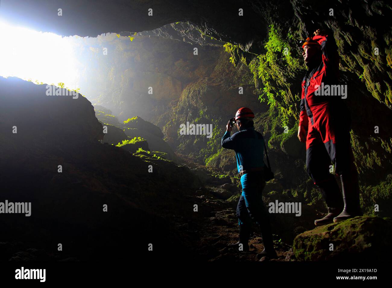 Cavers stand in twilight zone observing mouth of Gilap cave in ...