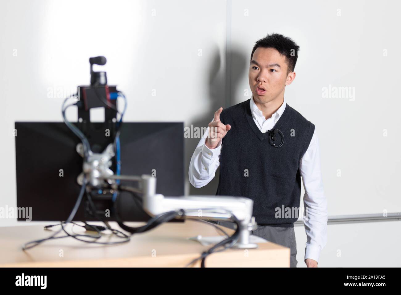 Young tutor is teaching in front of the camera for an online class ...