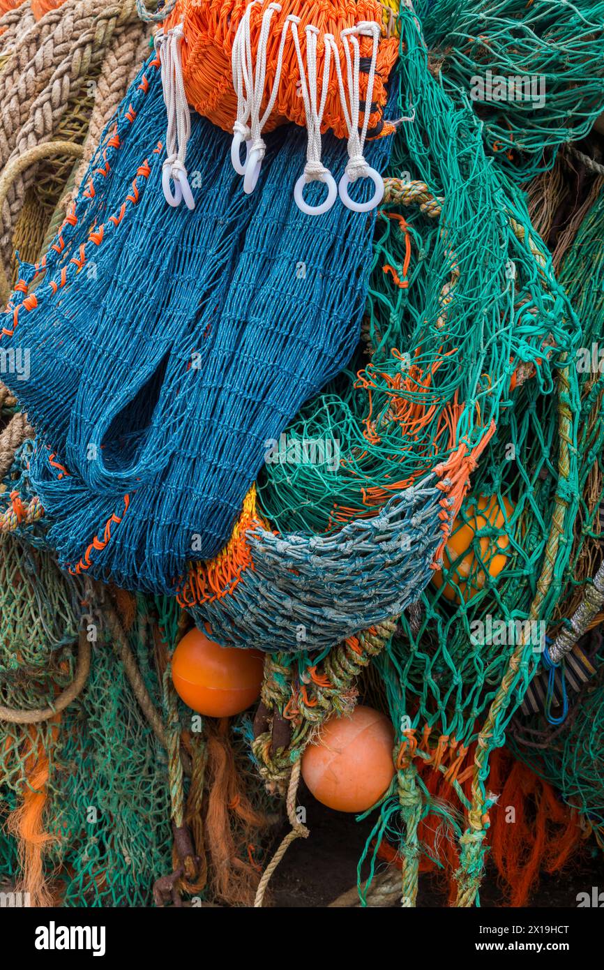 Fishing trawler nets hanging on the quay at Lyme Regis harbour, Dorset ...