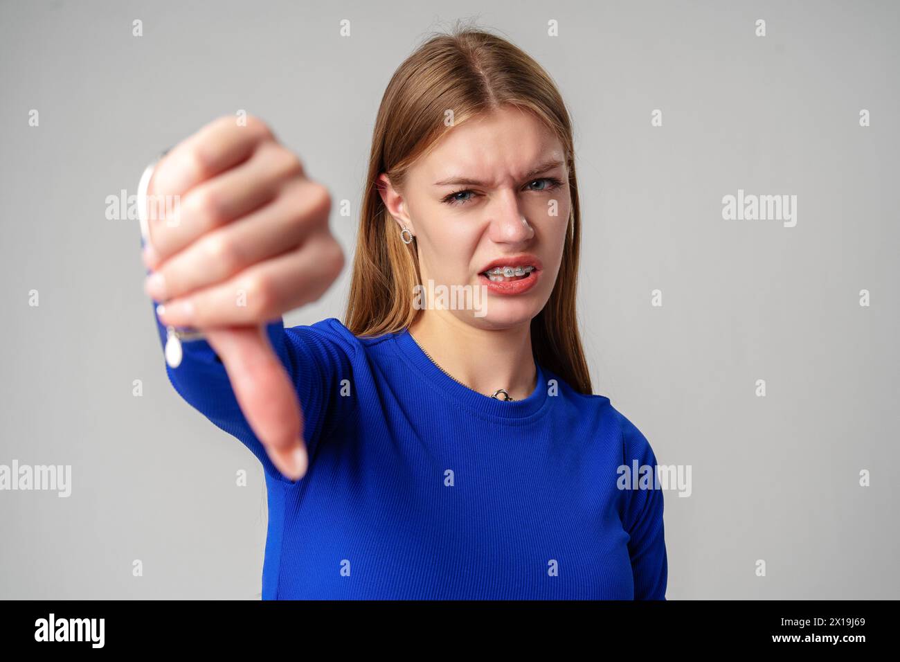 Young Woman Pointing Finger Down at Camera in studio Stock Photo - Alamy