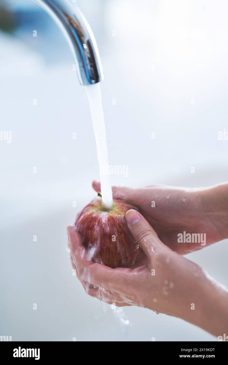 Water splash, hands and person cleaning apple, hygiene in kitchen with ...