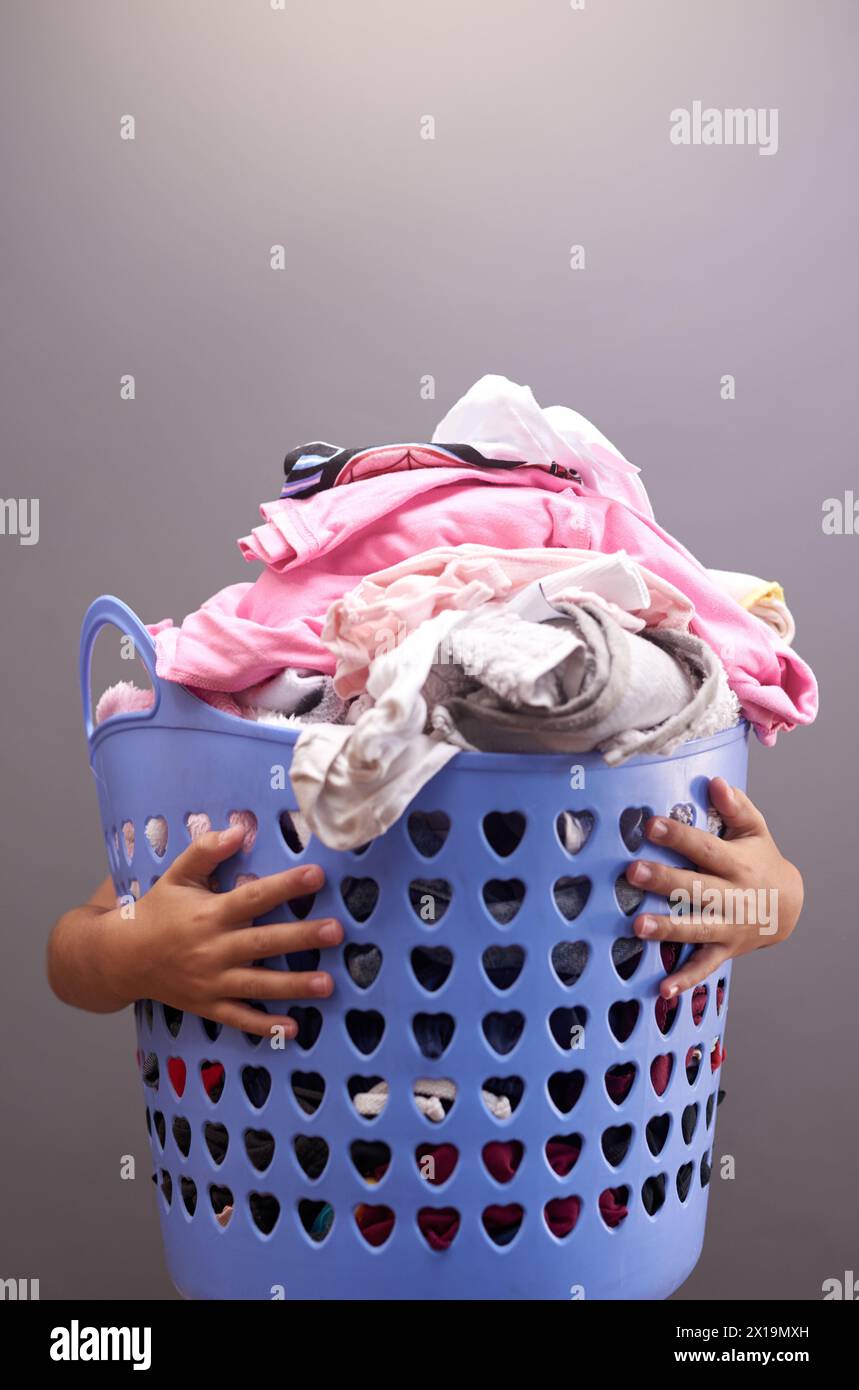 Laundry, child and basket in family home for development, cleaning and ...