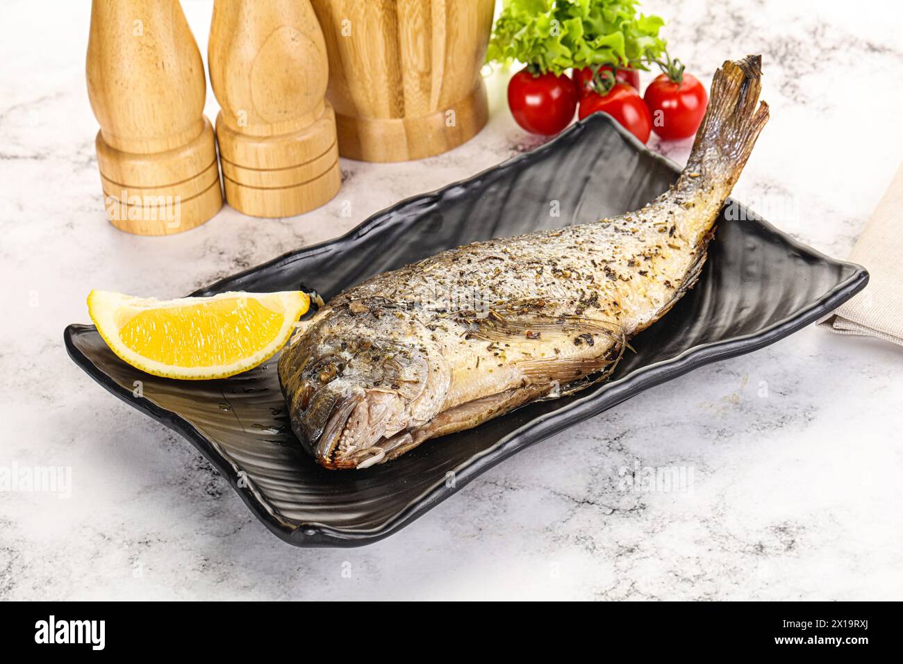 Baked Dorado fish served lemon slice Stock Photo - Alamy