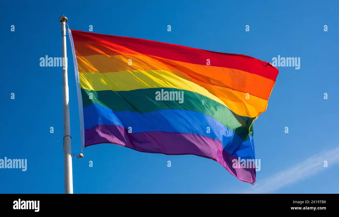 Die Regenbogenfahne flattert im Wind, isoliert, gegen den blauen Himmel ...