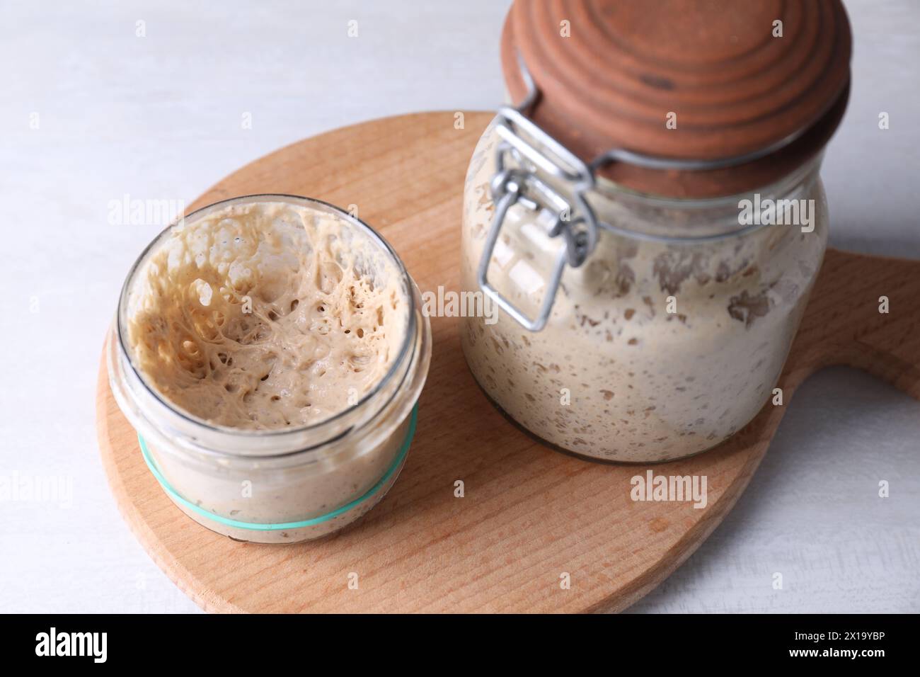 Sourdough starter in glass jars on light table Stock Photo - Alamy