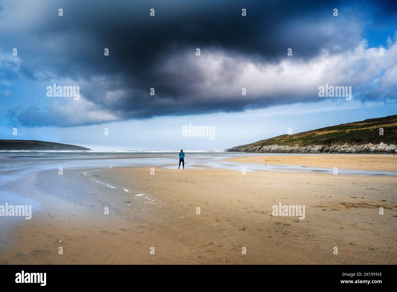 UK weather. A man standing alone watching dramatic rainclouds ...