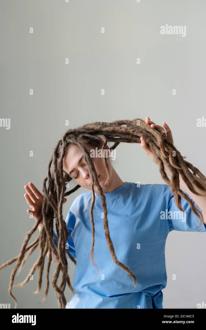 Minimal portrait of young Caucasian woman with long dreadlocks dancing ...