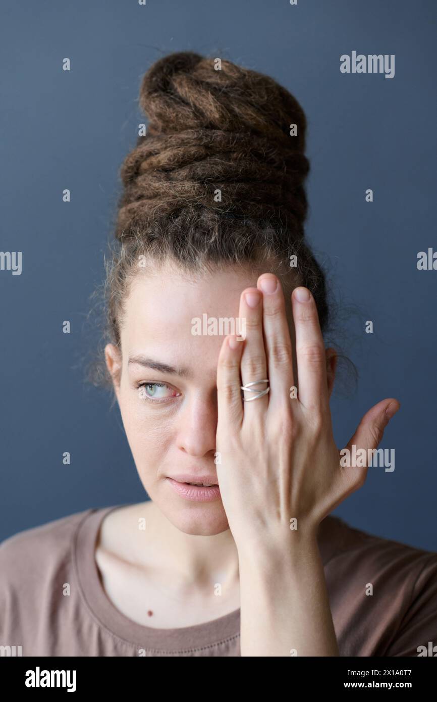 Vertical close up of Caucasian woman with dreadlocks in bun hairstyle ...