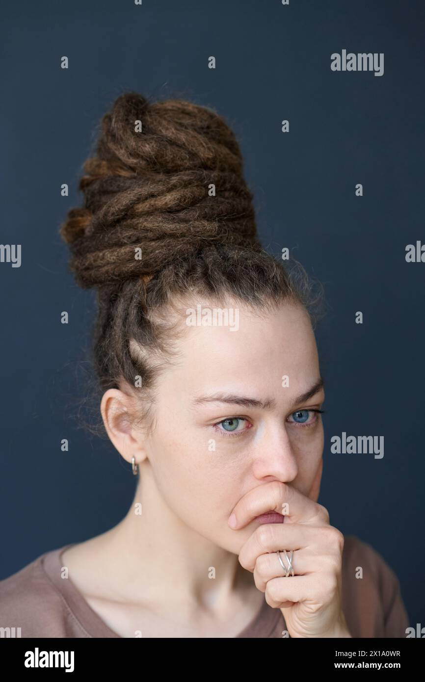 Vertical close up portrait of Caucasian woman with dreadlocks in bun ...