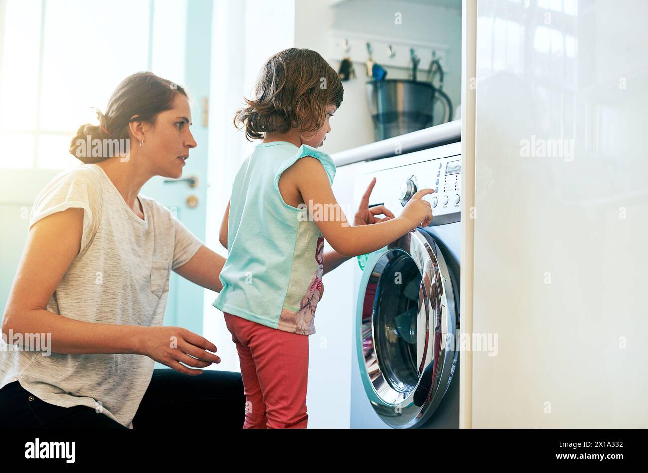 Help, home and mom with girl at washing machine for chores, teaching ...