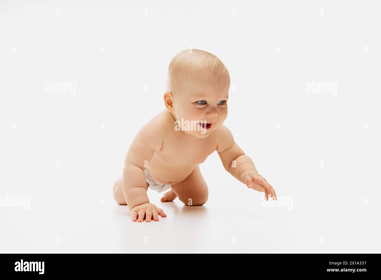 Charming, laughing little baby-girl in diaper crawls with playful ...