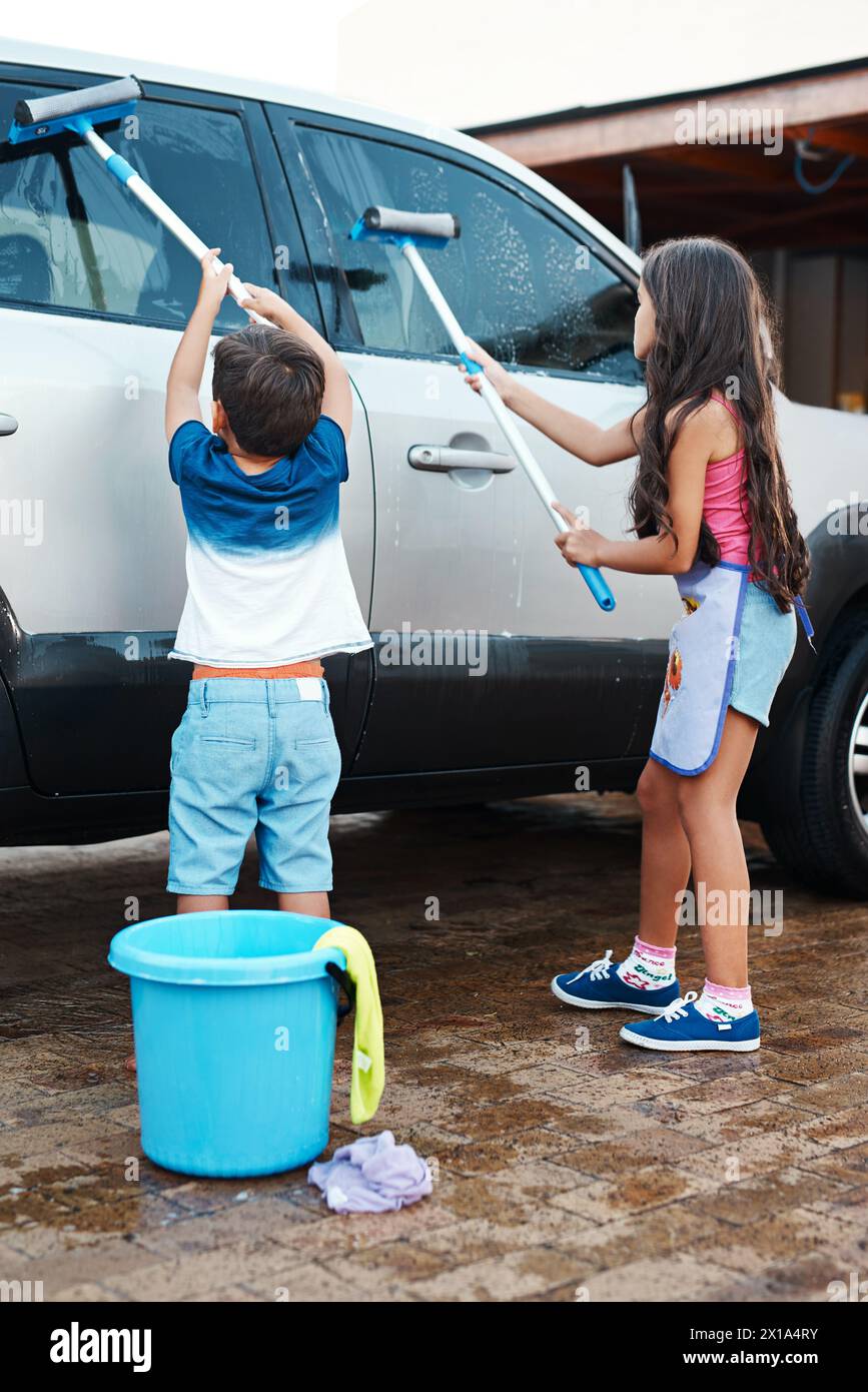 Children, clean and home or washing car, kids and motor vehicle with ...