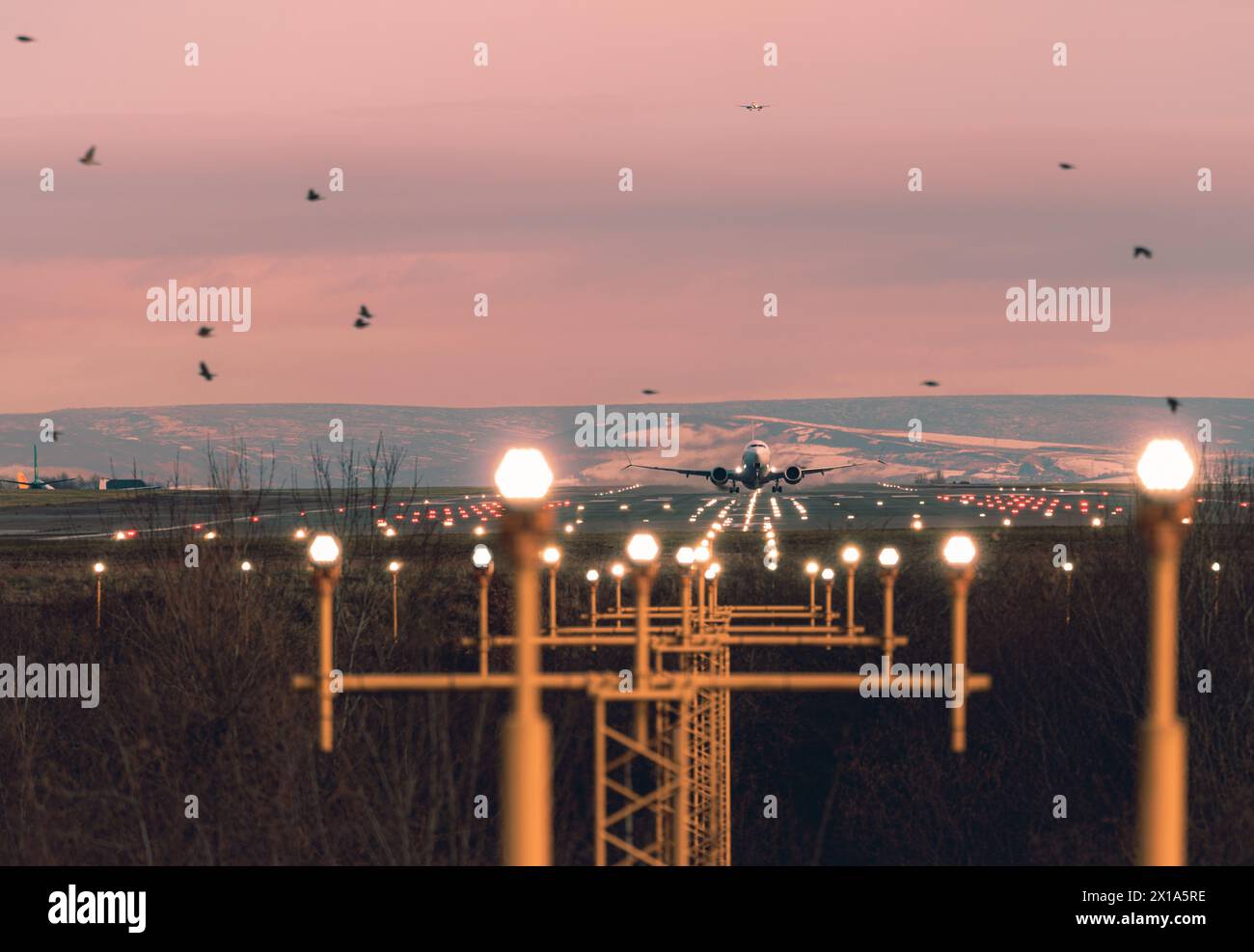 A airplane taking off from an airport looking down the runway head on ...
