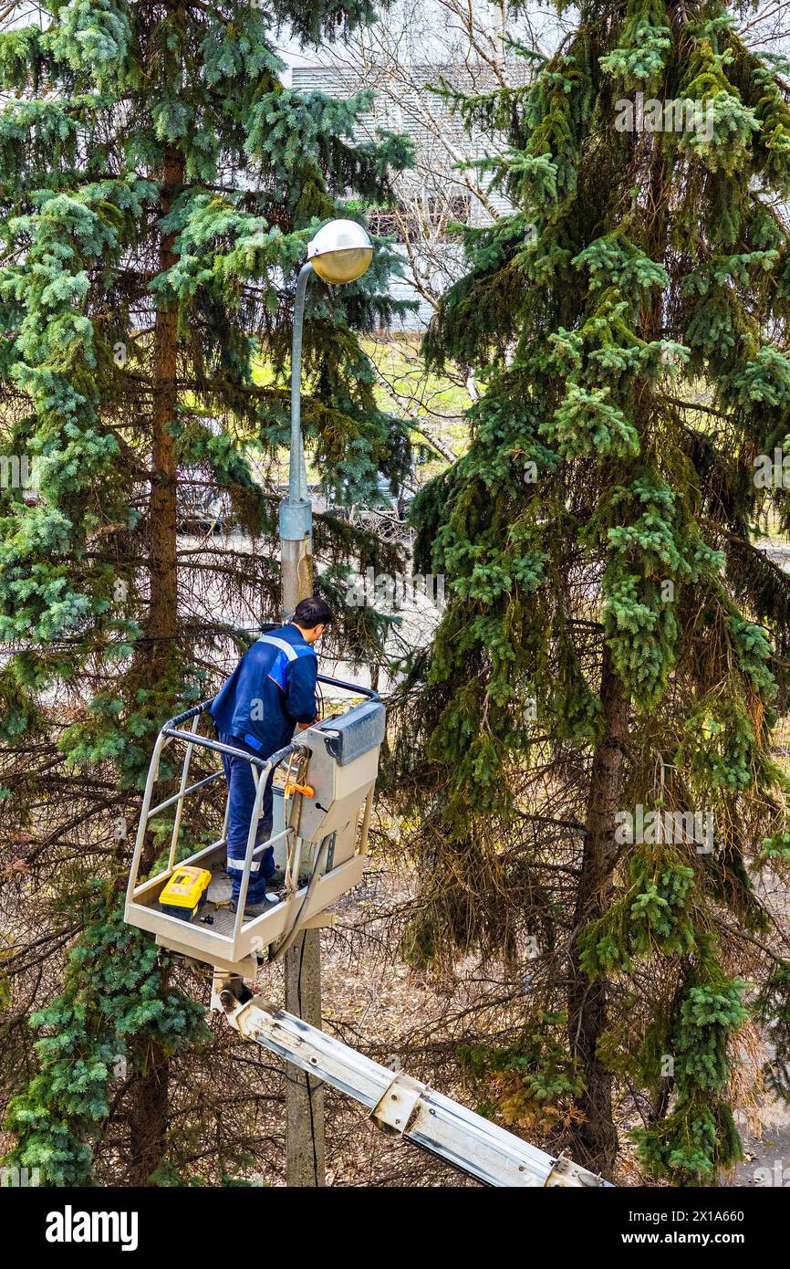 Moscow, Russia - April 10, 2024: Electrician repairs street lighting. a ...