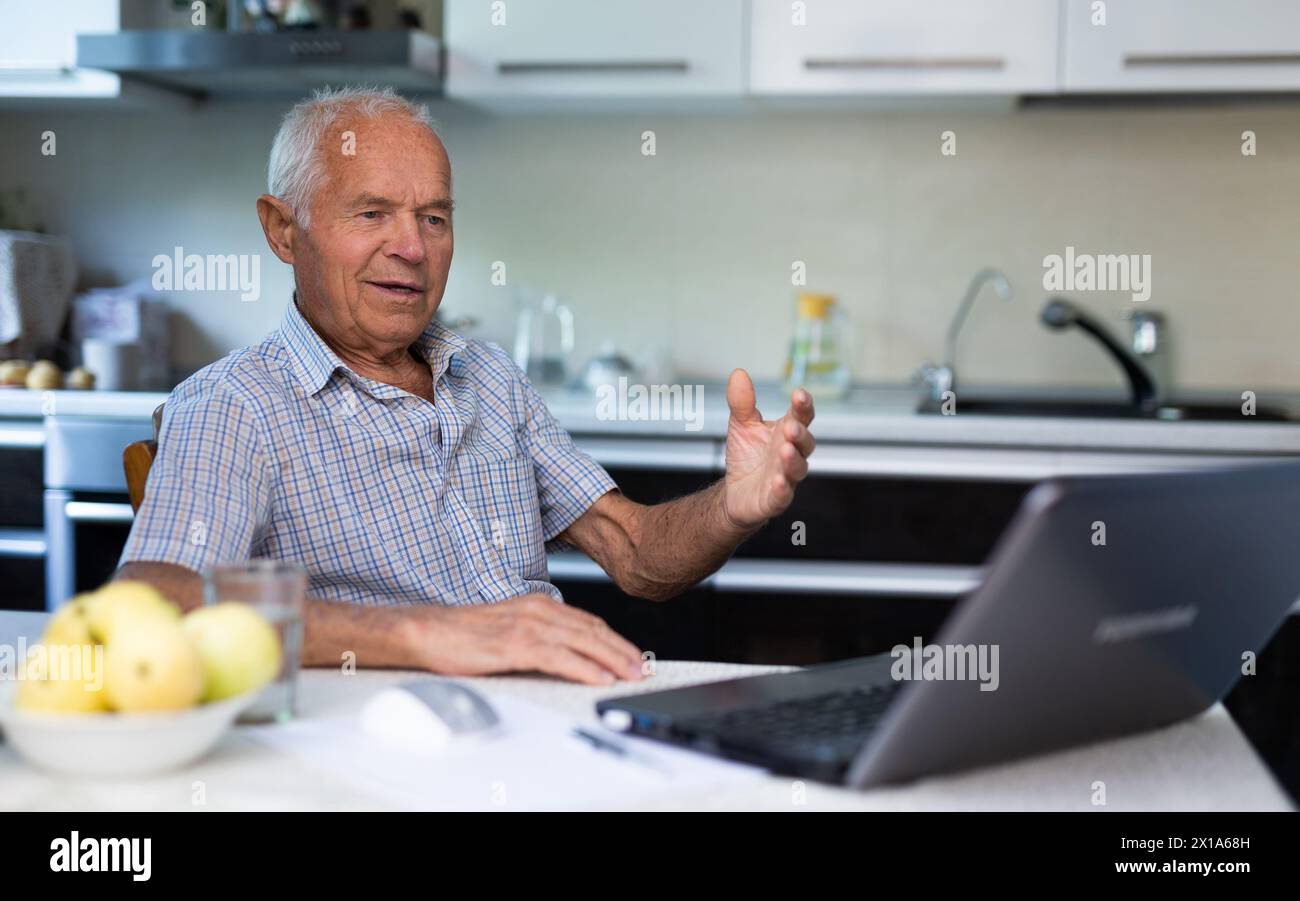 Old man with laptop talking through video call Stock Photo - Alamy