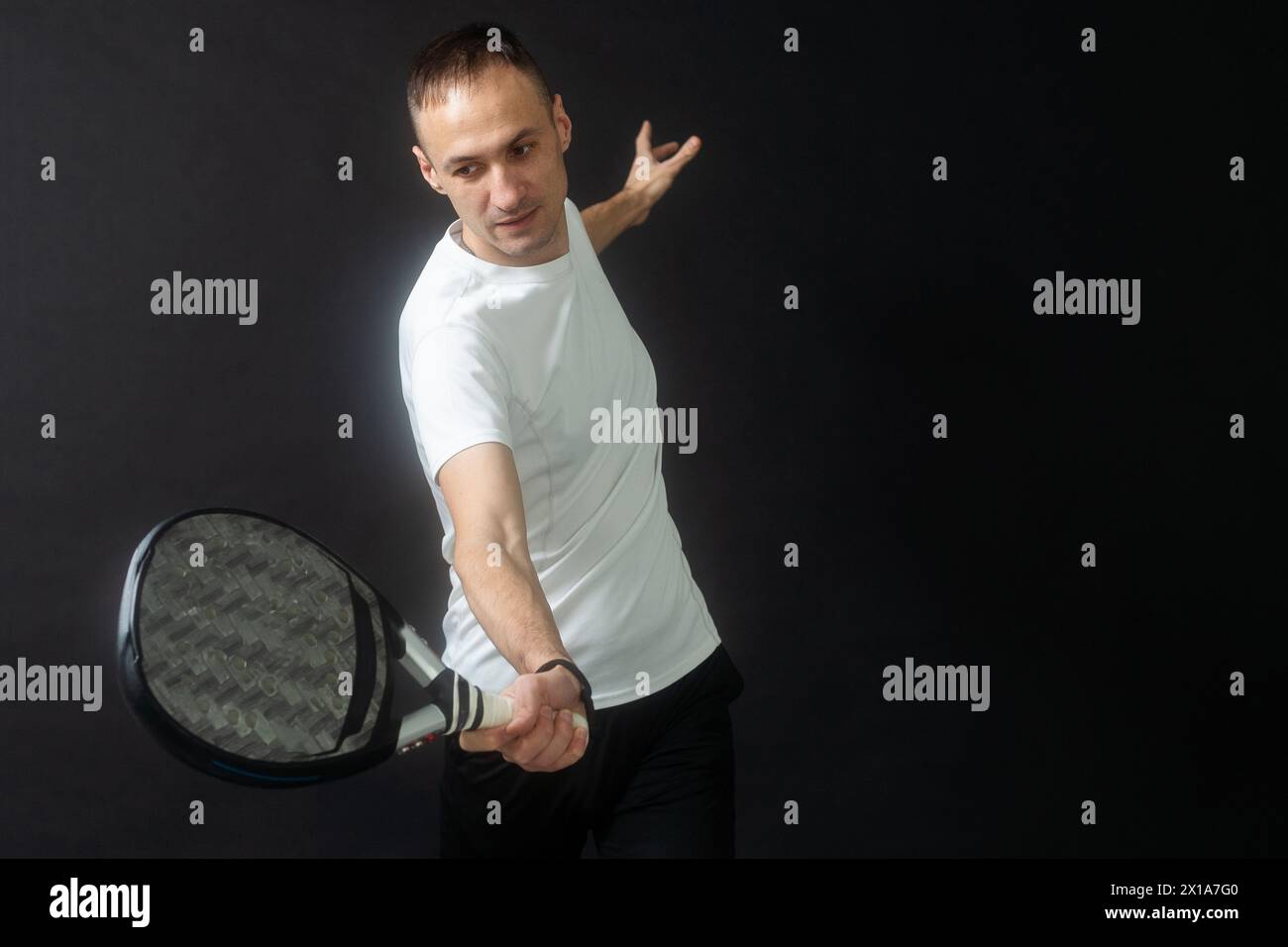 Portrait of man playing paddle tennis in position to hit a backhand ...