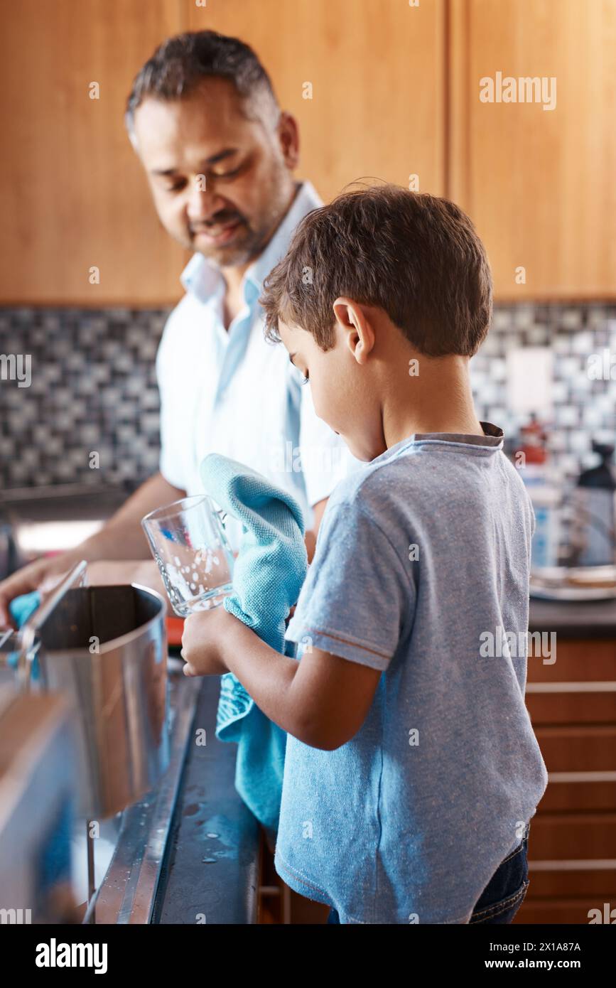 Child, help and father washing dishes in kitchen together for learning ...