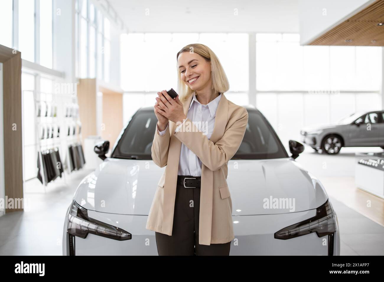 Happy smiling business lady standing near new bought car and hugging ...
