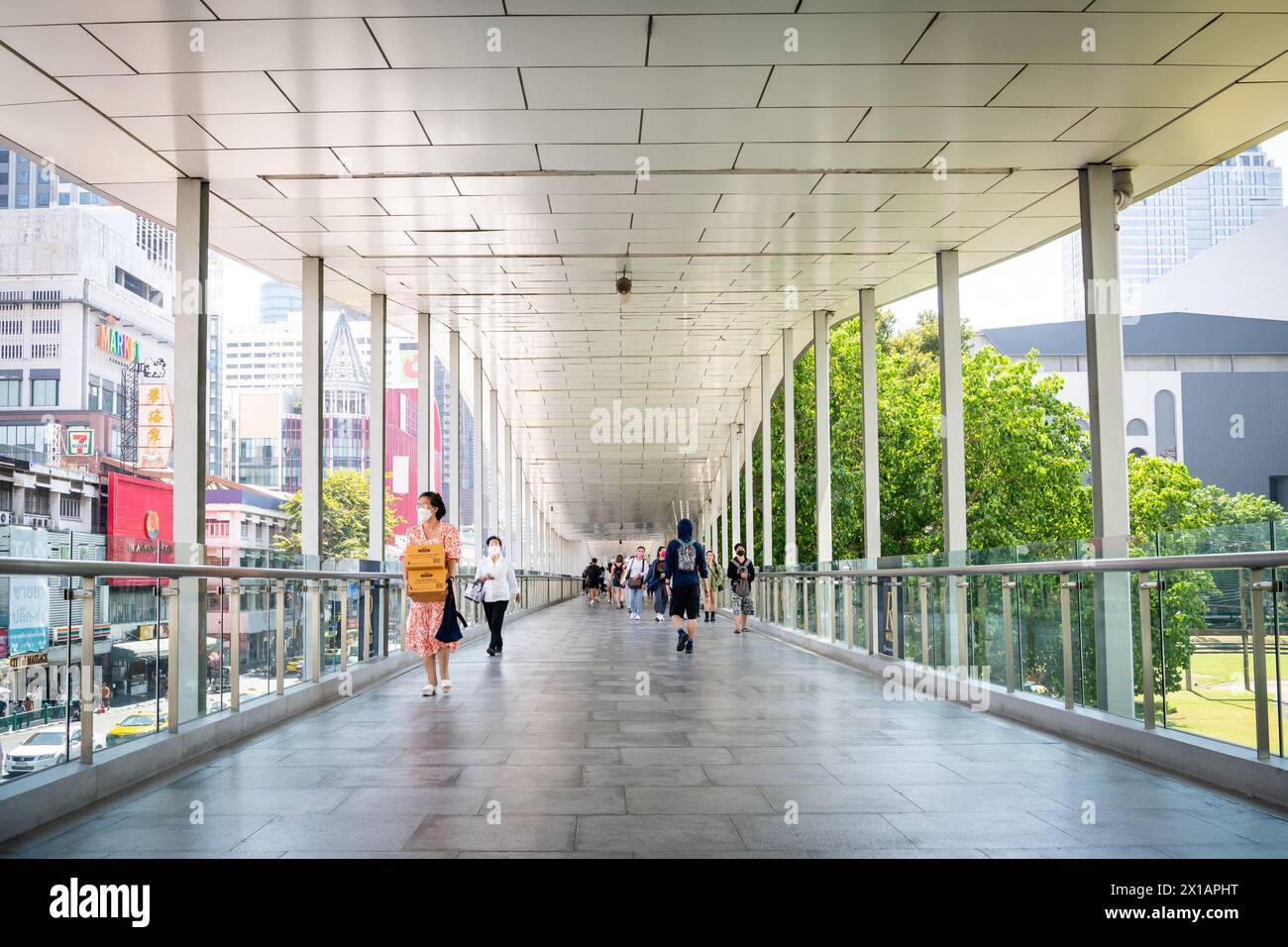 Pedestrians make their way along Ratchaprasong Sky Walk, above ...