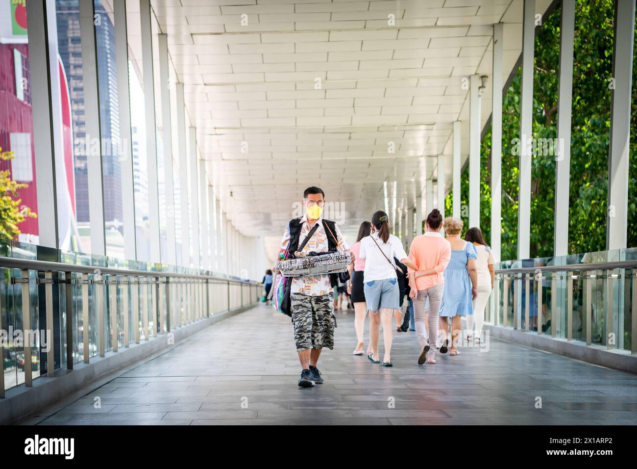 A mobile market trader makes his way along Ratchaprasong Sky Walk ...