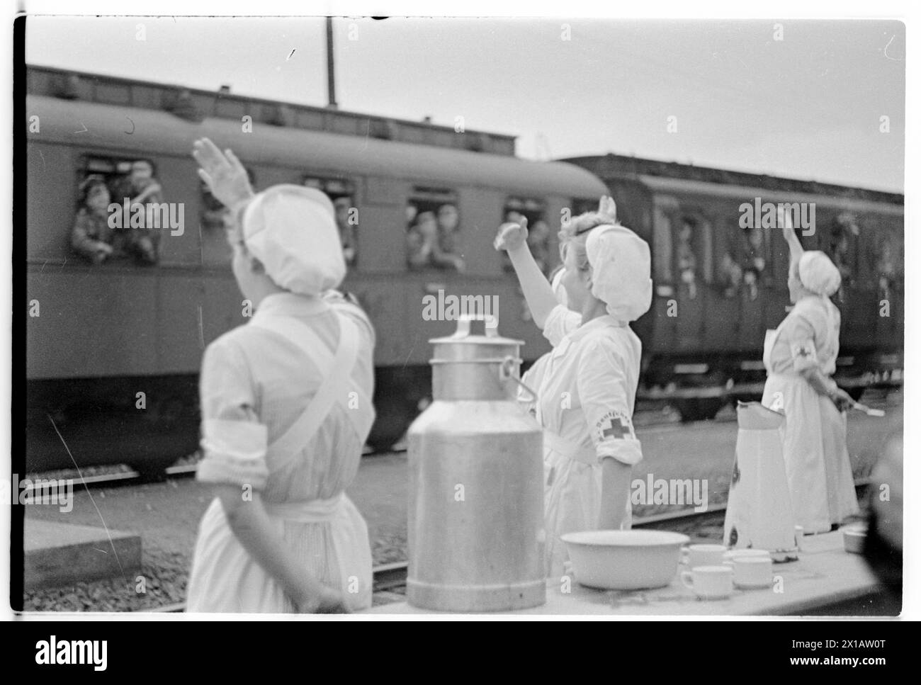 Troop transport on an railway station, Red Cross nurses beckon an train ...