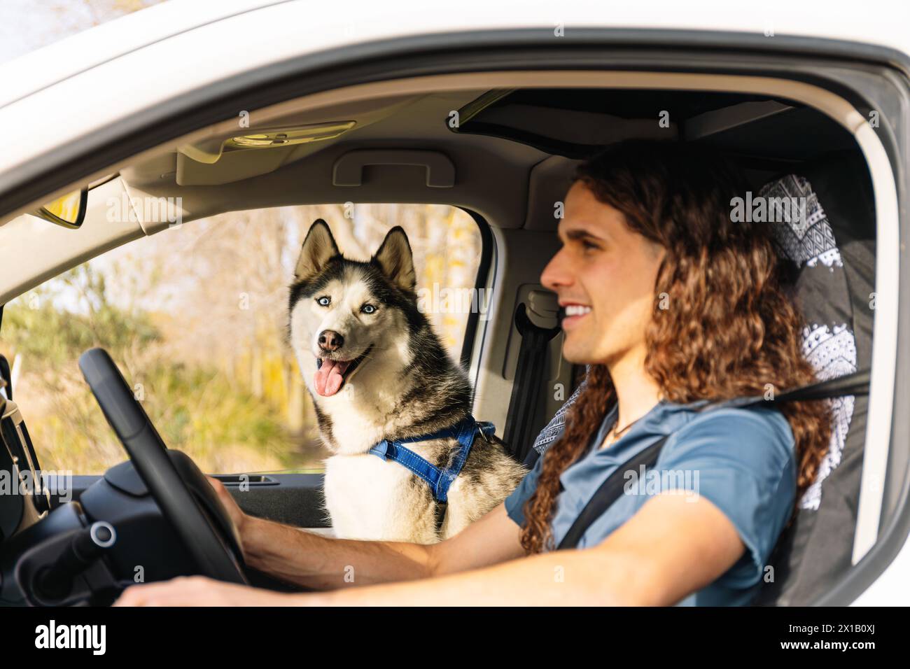 Horizontal photo a radiant man with long curly hair shares a driving ...