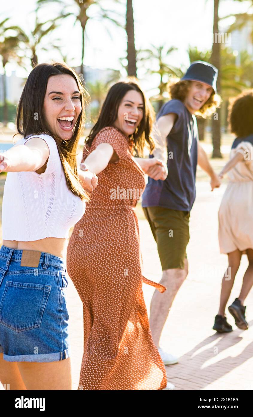 Multiethnic group of young friends running happily together Stock Photo ...