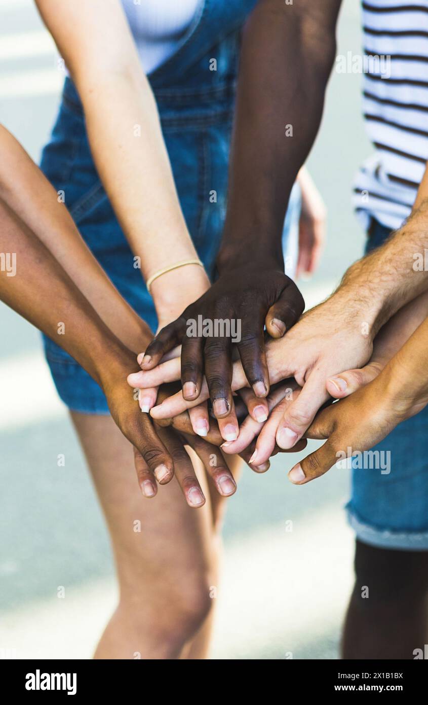 Millennial people celebrating together outdoor and stacking hands ...