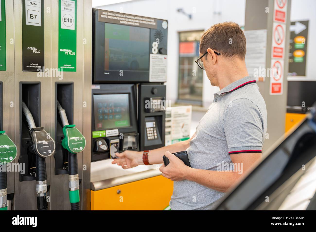 The man pays for fuel with a credit card on terminal of self-service ...