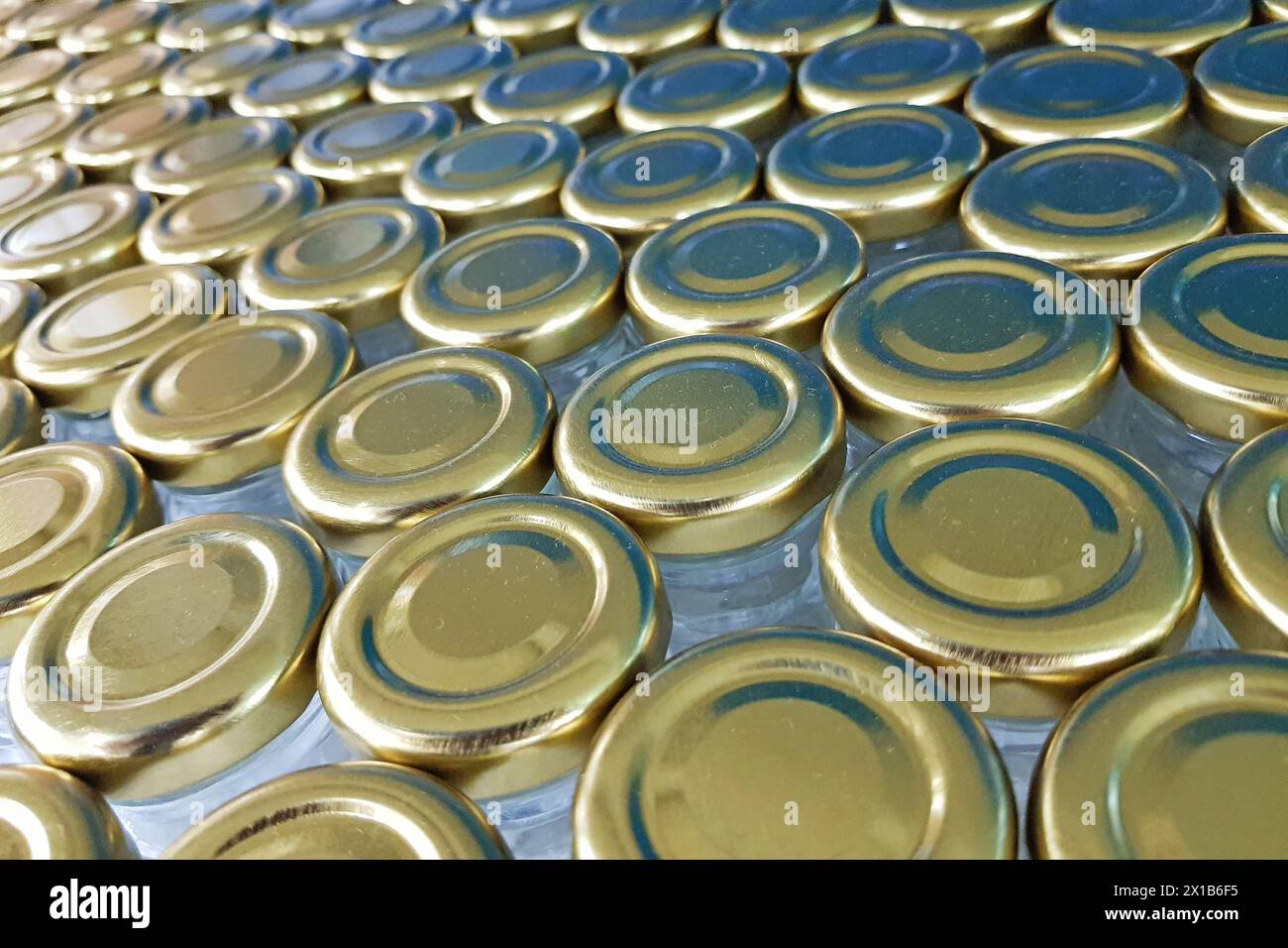 Golden lids and glass jar background Stock Photo - Alamy