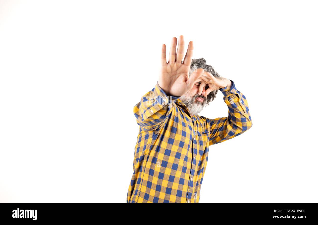 Bearded man in checkered shirt smelling something smelly and disgusting ...