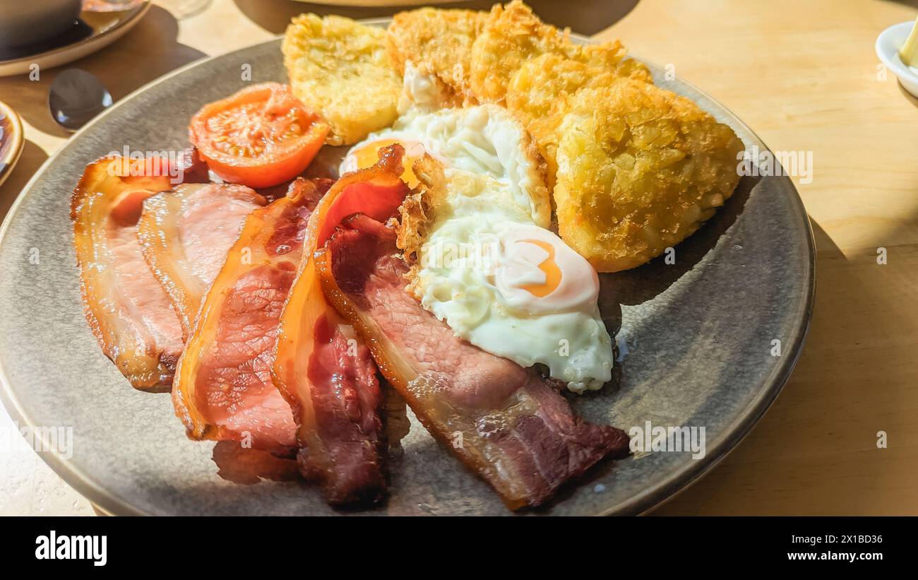 Traditional English breakfast consisting of bacon, eggs, tomato and hash browns Stock Photo - Alamy