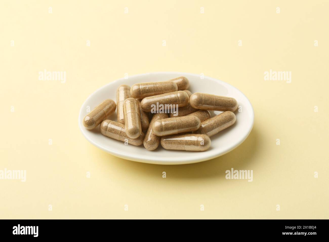 Vitamin capsules on pale yellow background. Health supplement Stock ...